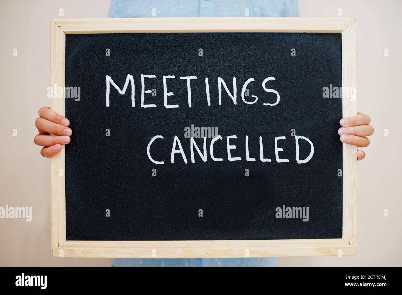 Meetings cancelled. Coronavirus concept. Boy hold inscription on the ...