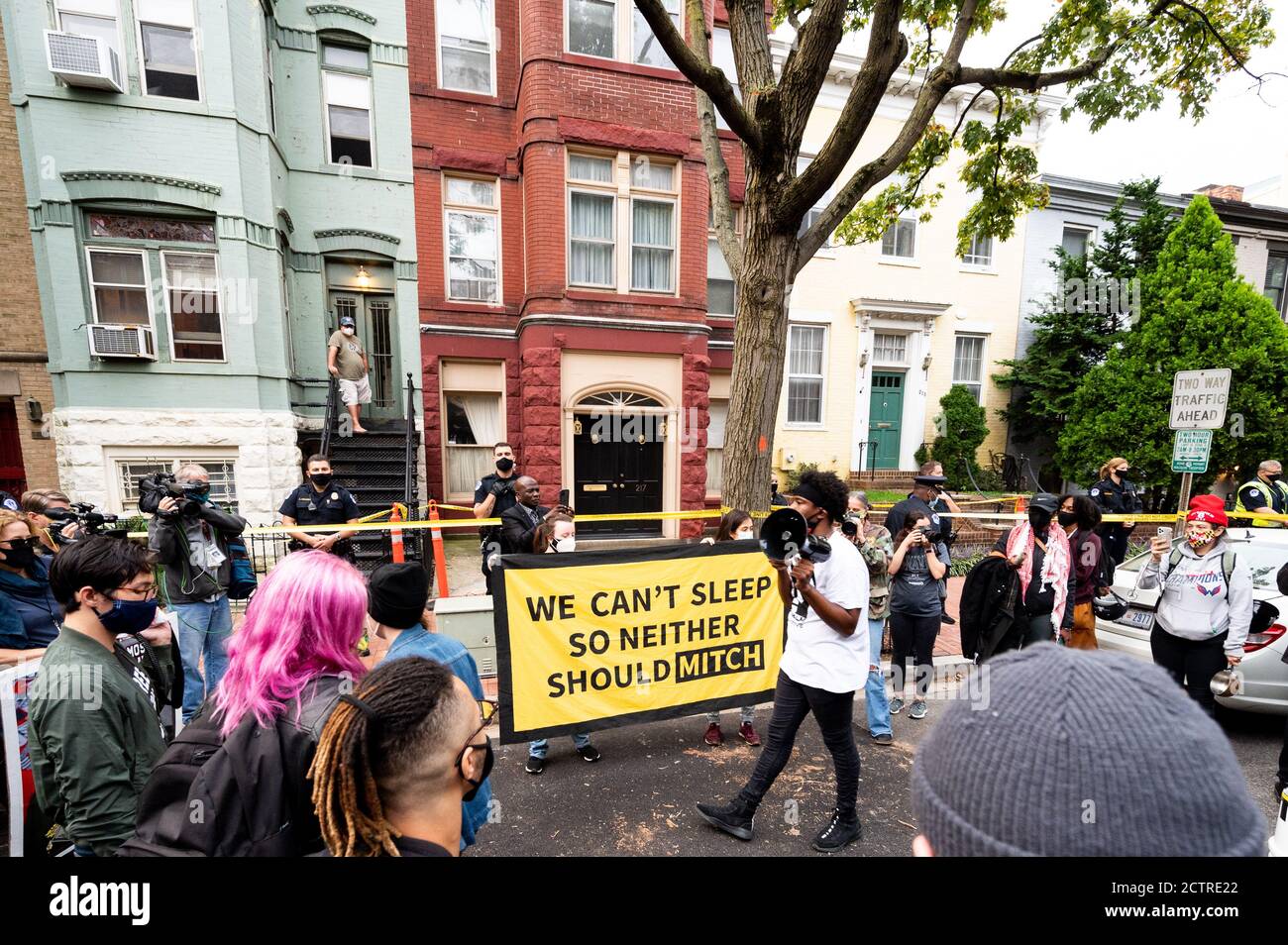 Protesters hold a banner saying We can't sleep so neither should Mitch ...
