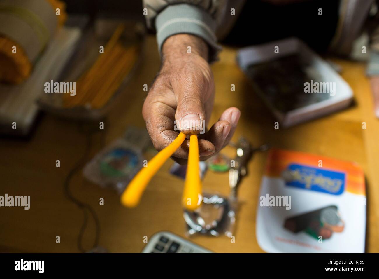 The attendant in the church offers a couple of votive candles for a ...