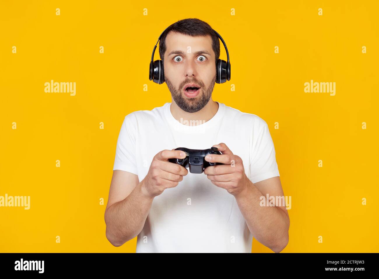 Young man with beard in white t-shirt gamer playing video games with ...