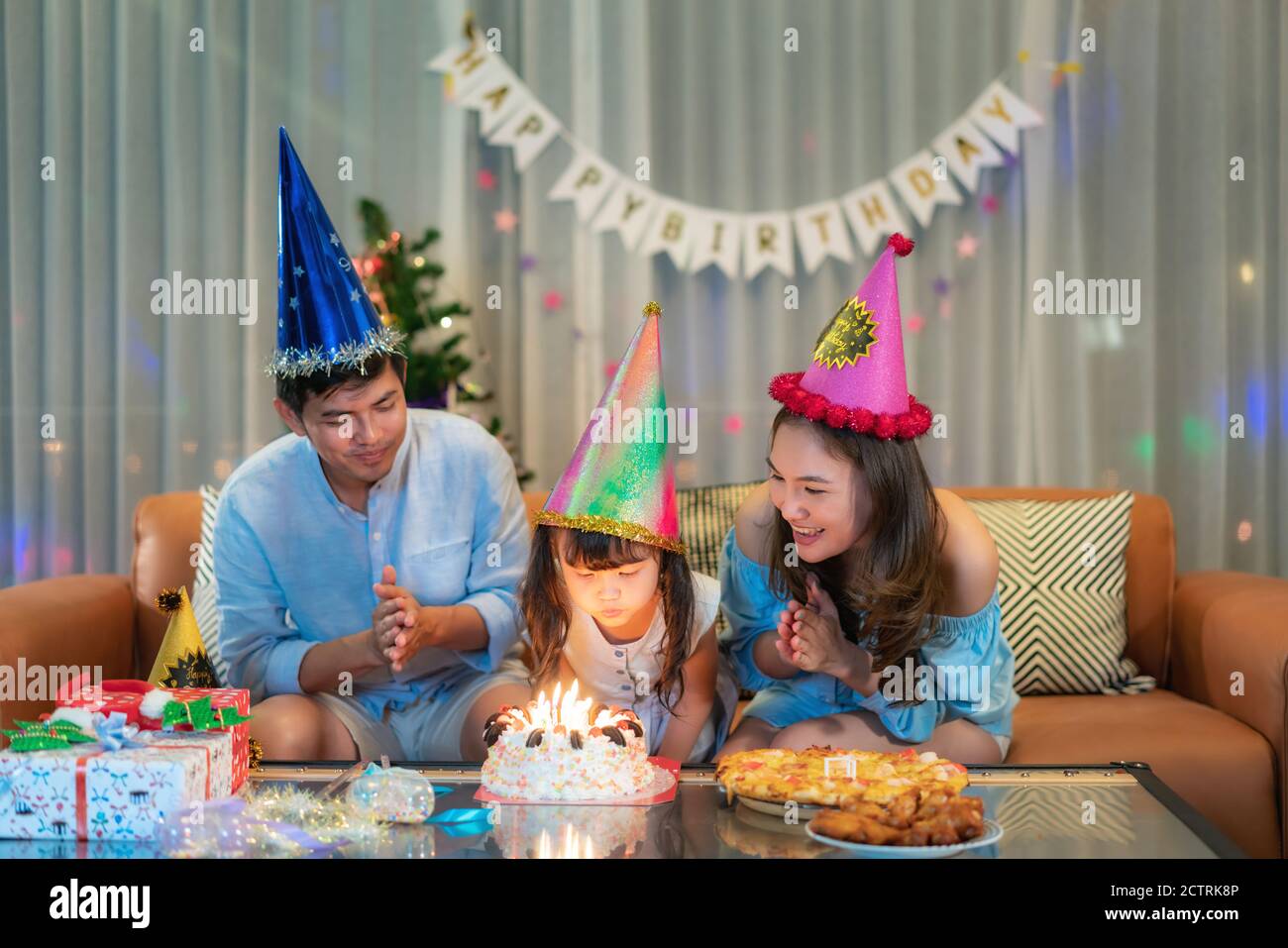 Asian happy family in a birthday party for her daughter while daughter ...