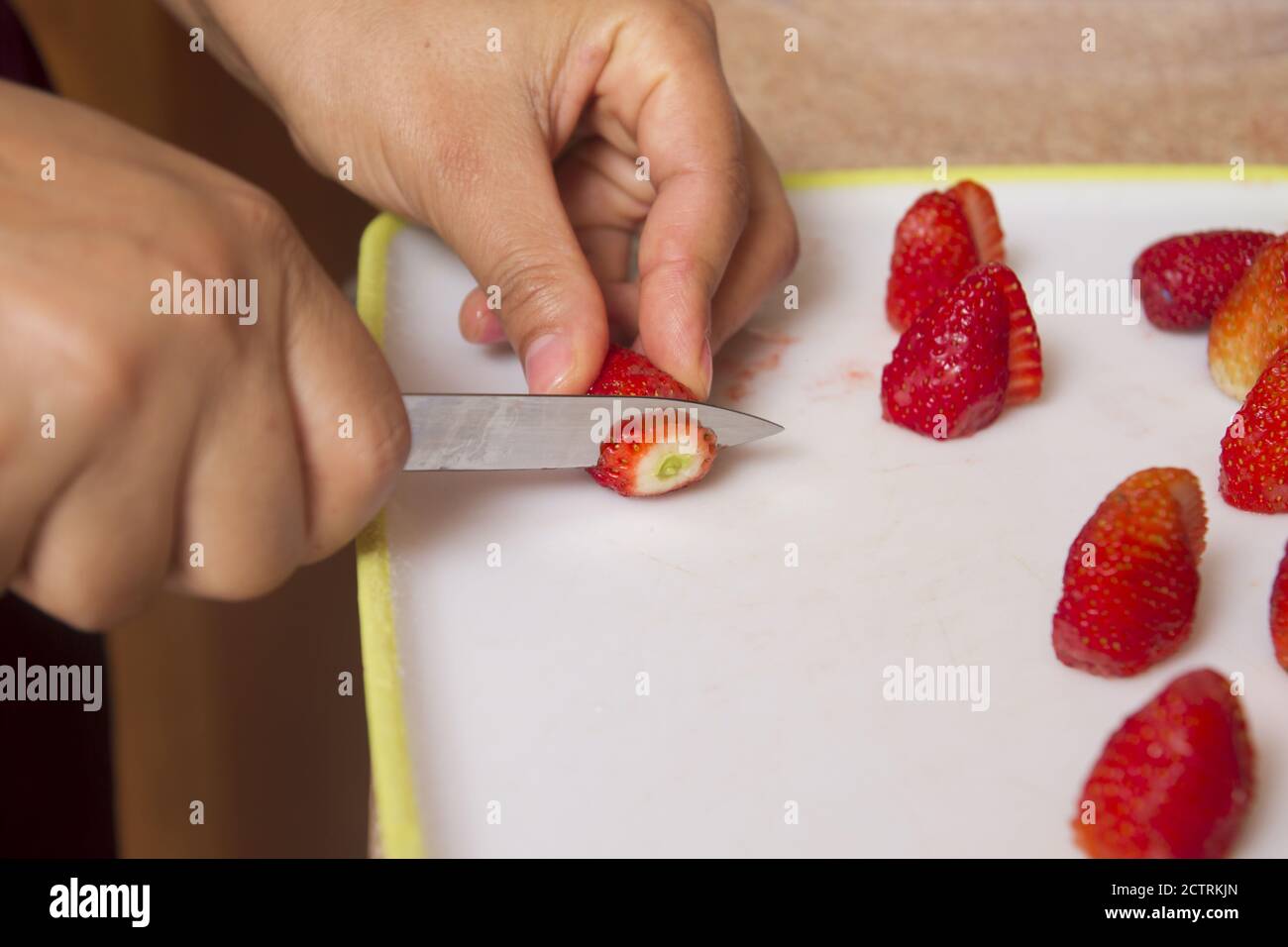 anonymous woman hands cutting strawberries on white plastic board Stock ...