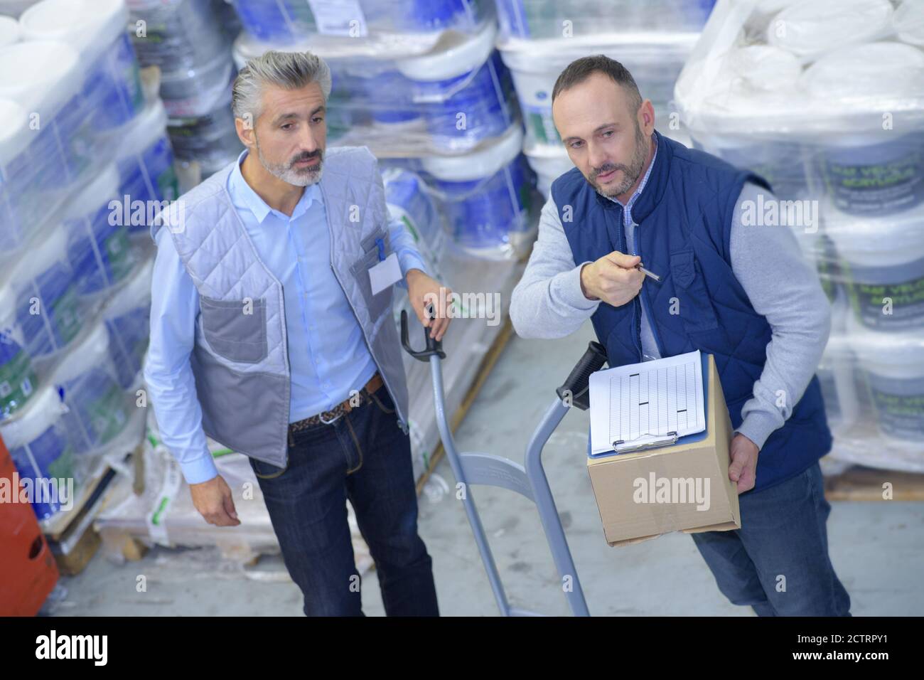 two men checking supply stock in the warehouse Stock Photo - Alamy