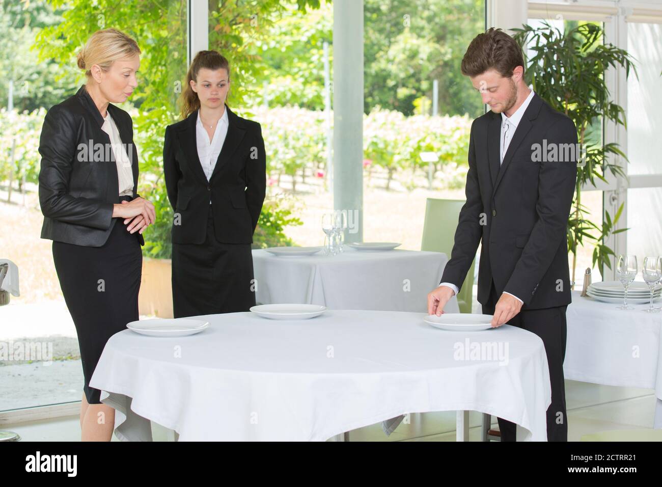 female restaurant manager talking to staff memebers Stock Photo - Alamy