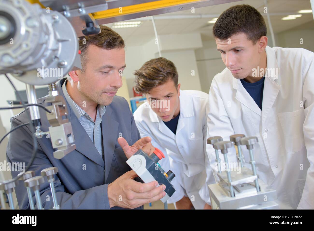 Teacher showing students the emergency stop button Stock Photo - Alamy