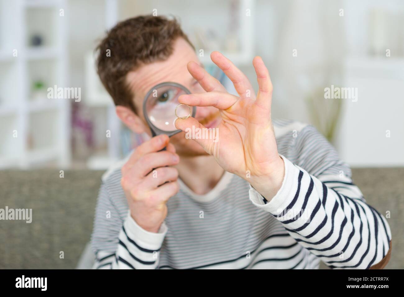 man looking though a magnifying glass at his coin collection Stock ...