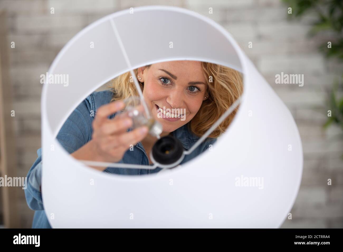 Pretty woman changing light bulb hi-res stock photography and images ...