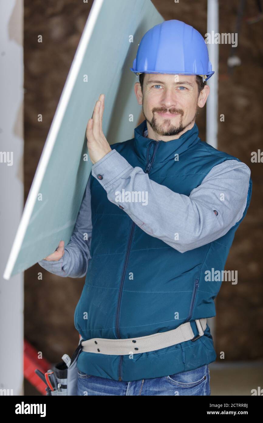 construction man is carrying a board Stock Photo - Alamy