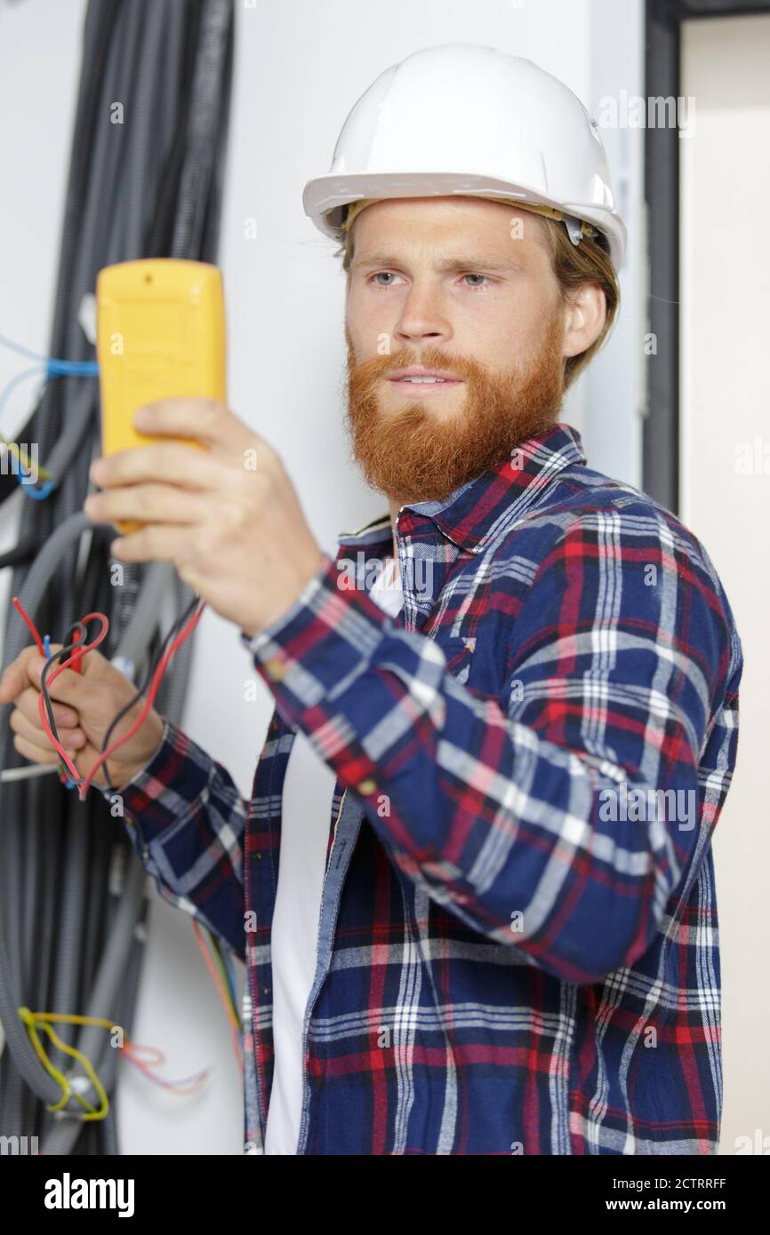 electrical engineer makes adjustments in front of a metal box Stock ...