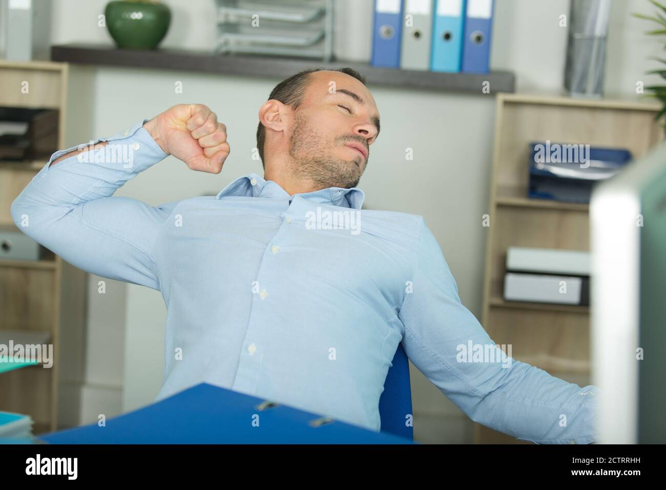 businessman stretching in the office Stock Photo - Alamy