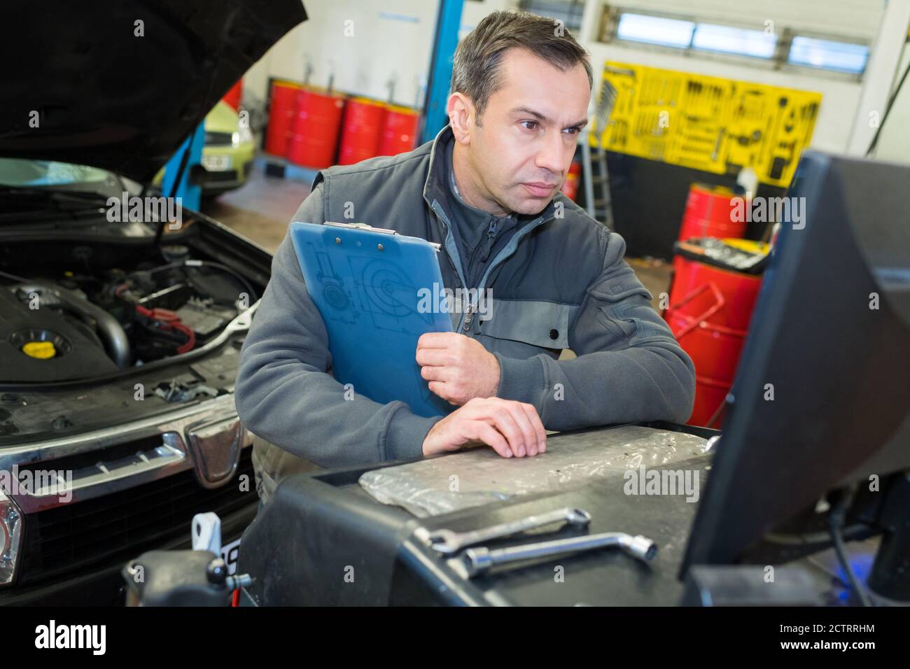 mechanic using laptop for checking car engine Stock Photo - Alamy
