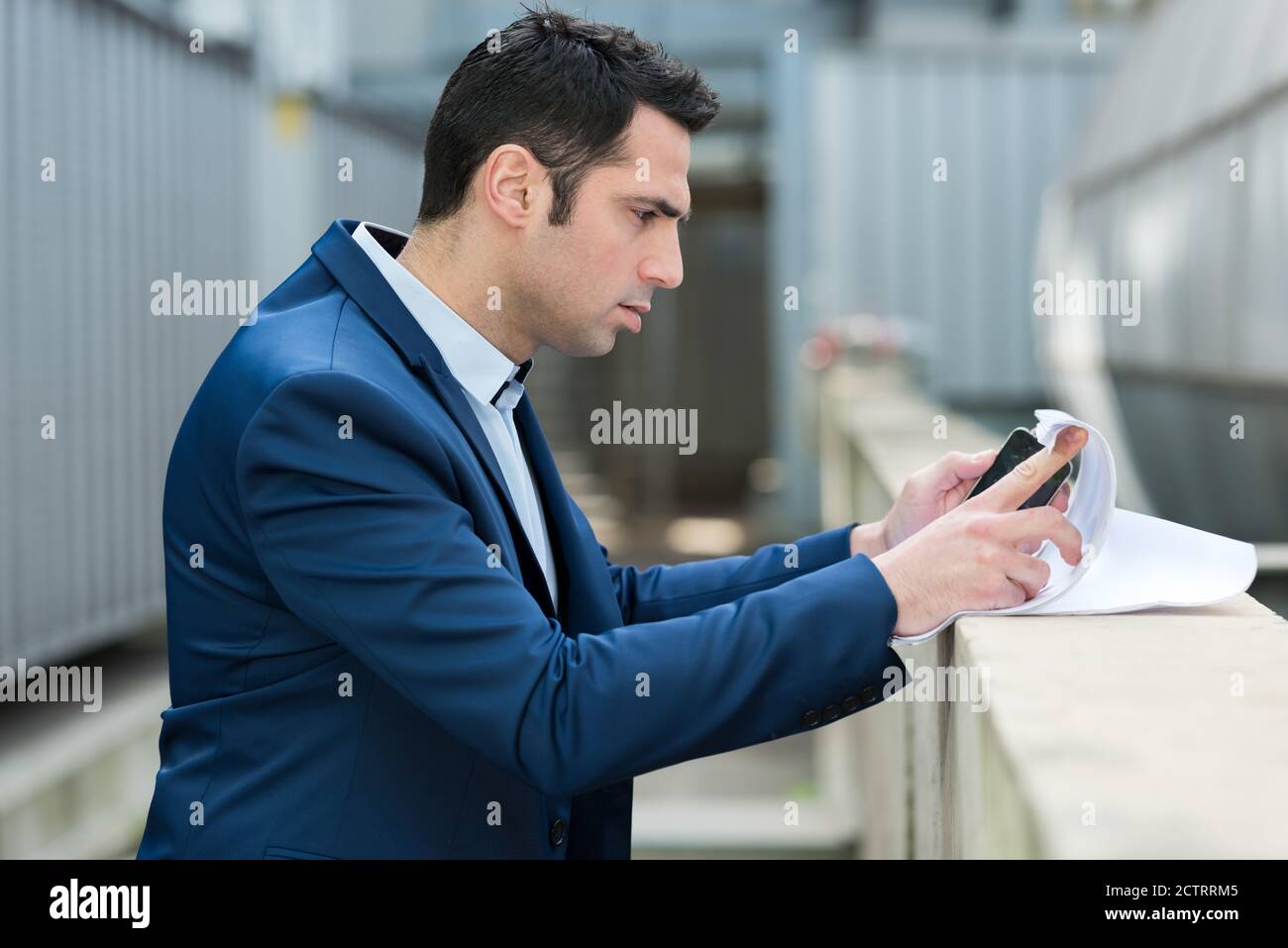 engineer in formal wear holding blueprint Stock Photo - Alamy