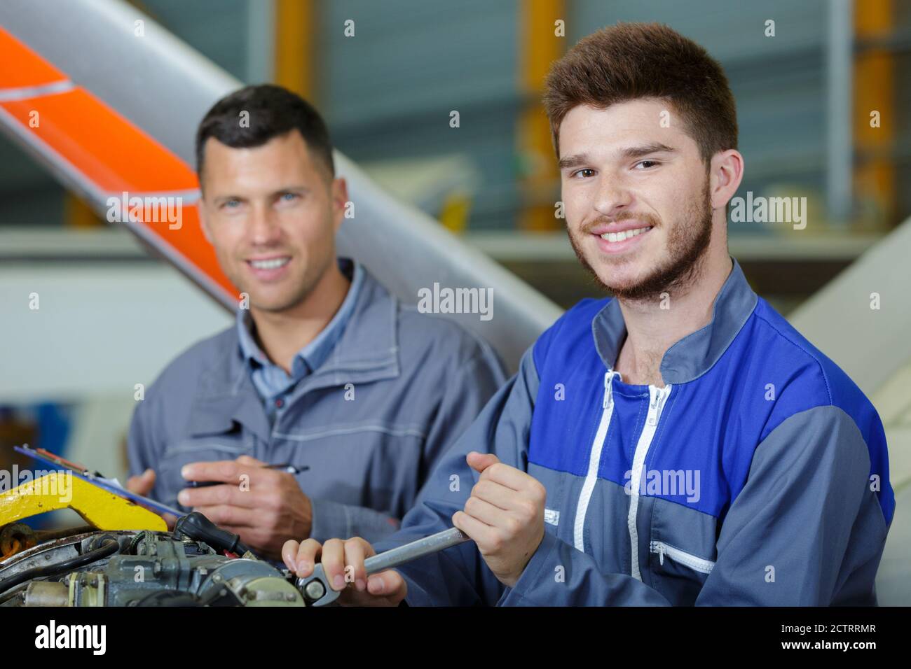 two flight engineers working in aircraft hangar Stock Photo - Alamy