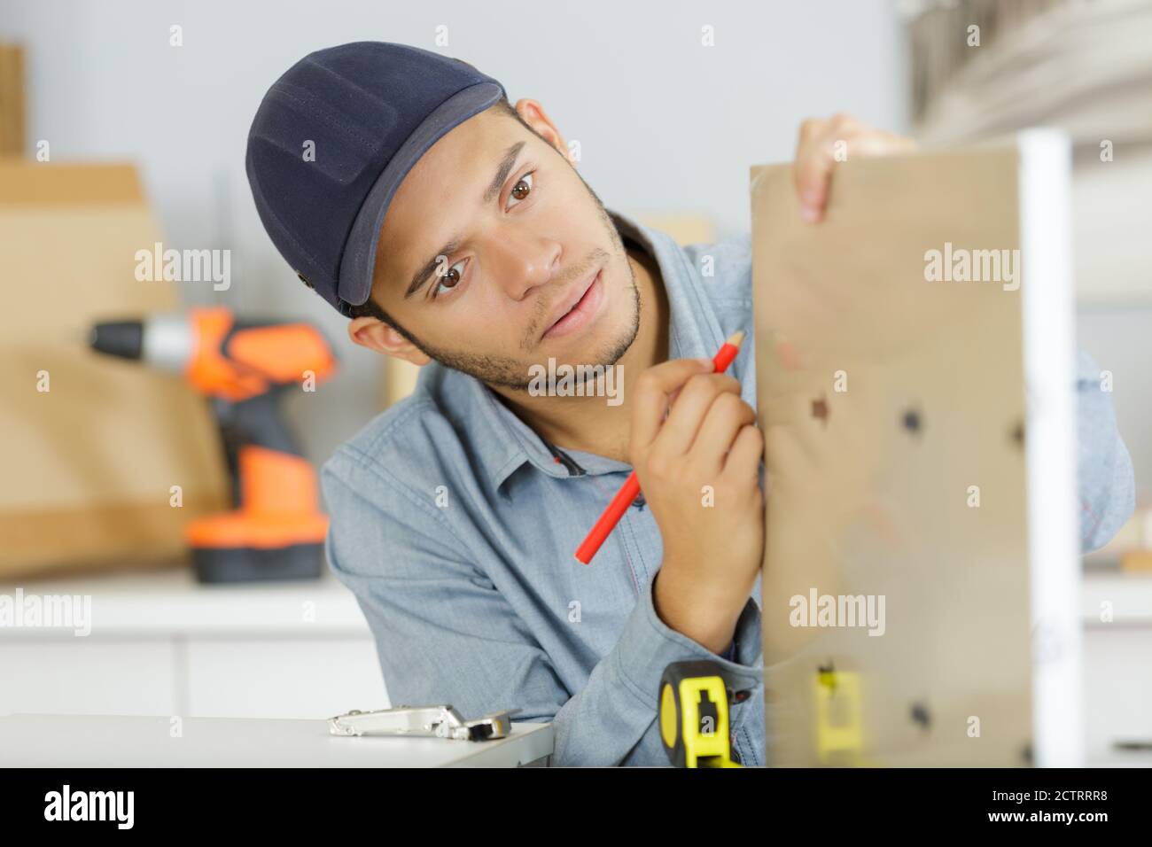 young man fixing a cupboard Stock Photo - Alamy