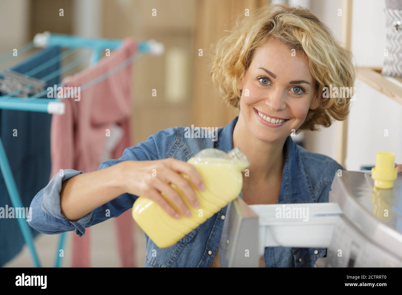 woman pouring fabric conditioner into washing machine drawer Stock ...