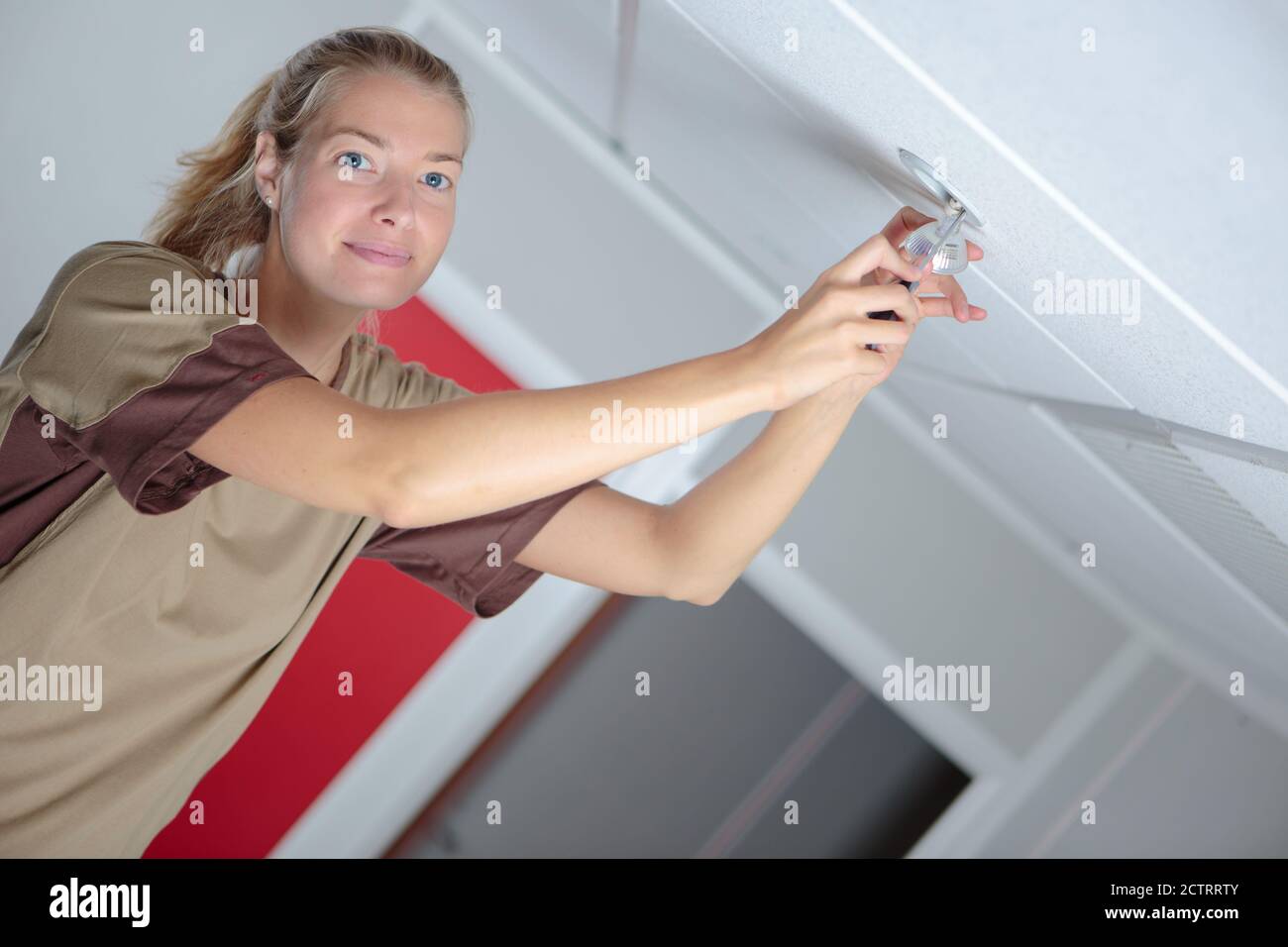 woman pulling to the ceiling in repair Stock Photo - Alamy