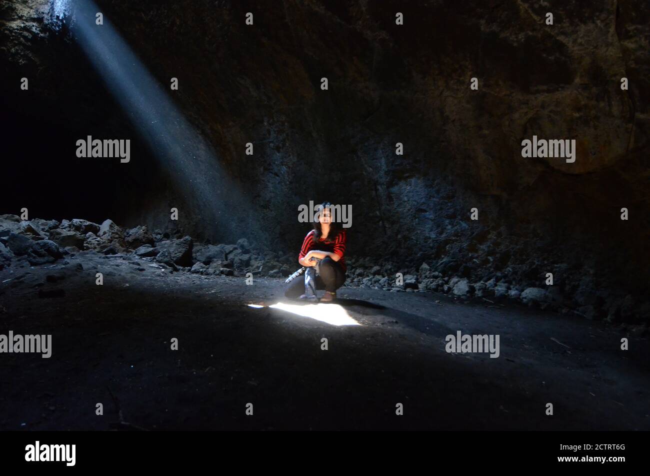 Women sitting in the Skylight cave enjoying the ray of light, Deschutes ...