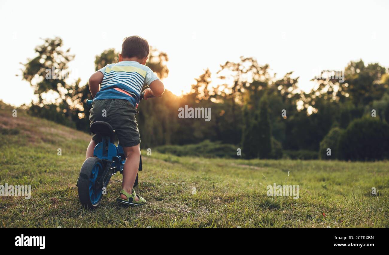 Back view boy on bicycle hi-res stock photography and images - Alamy