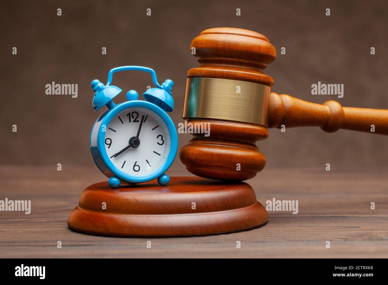 Alarm clock and hammer judge gavel on brown background Stock Photo - Alamy