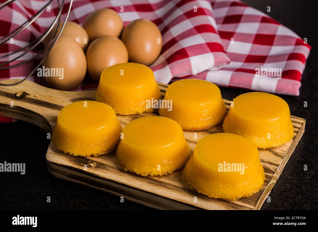 Delicious Quindins on wooden board, traditional Brazilian dessert made ...
