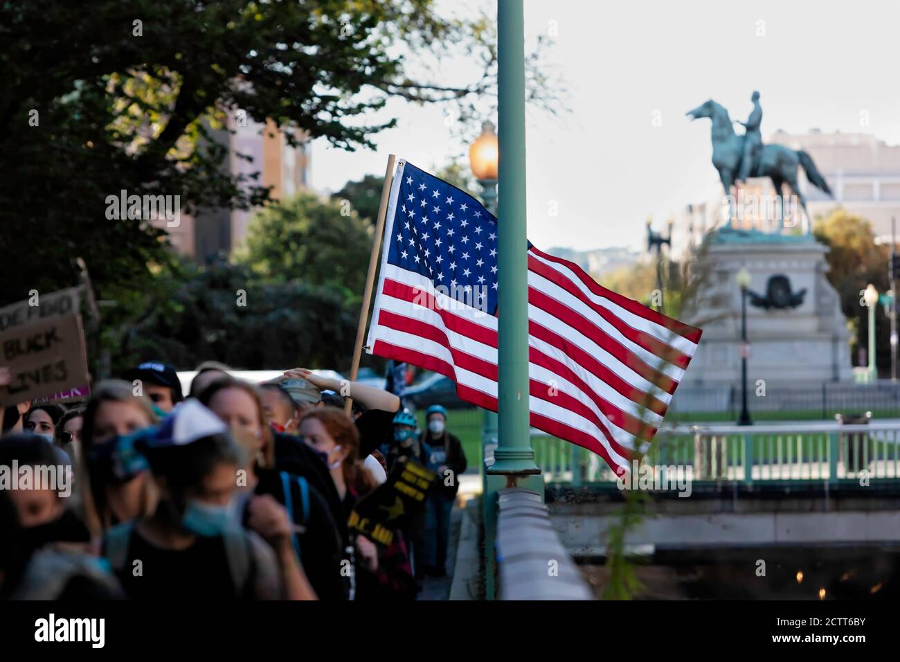 A military veteran carries an American flag as protesters Lae Thomas ...