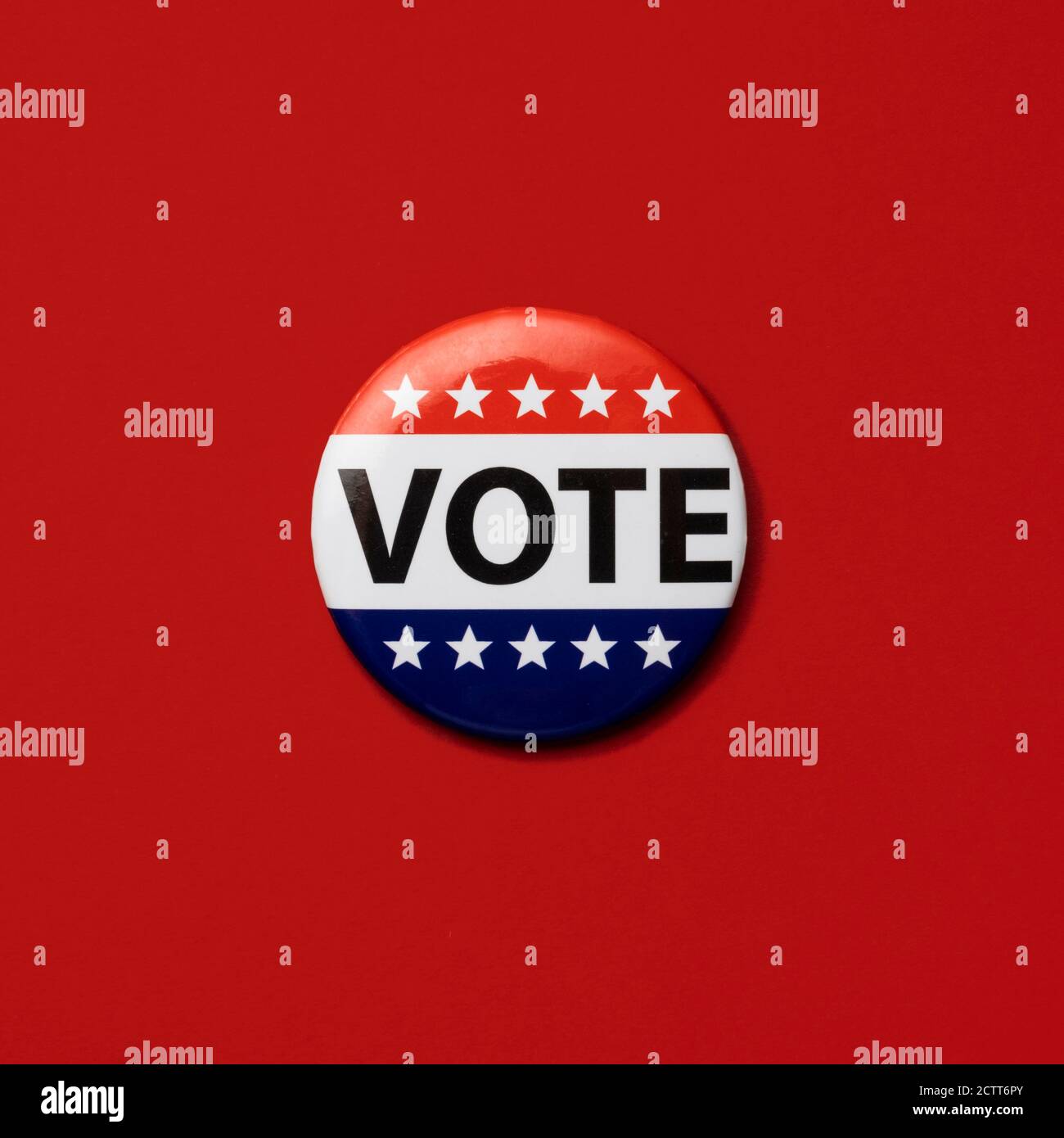 Vote badge on red background Stock Photo - Alamy