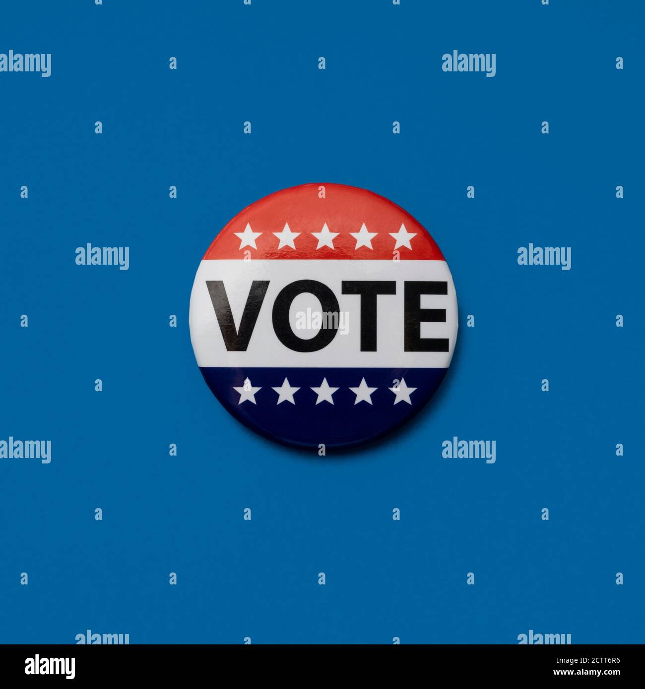 Vote badge on blue background Stock Photo - Alamy