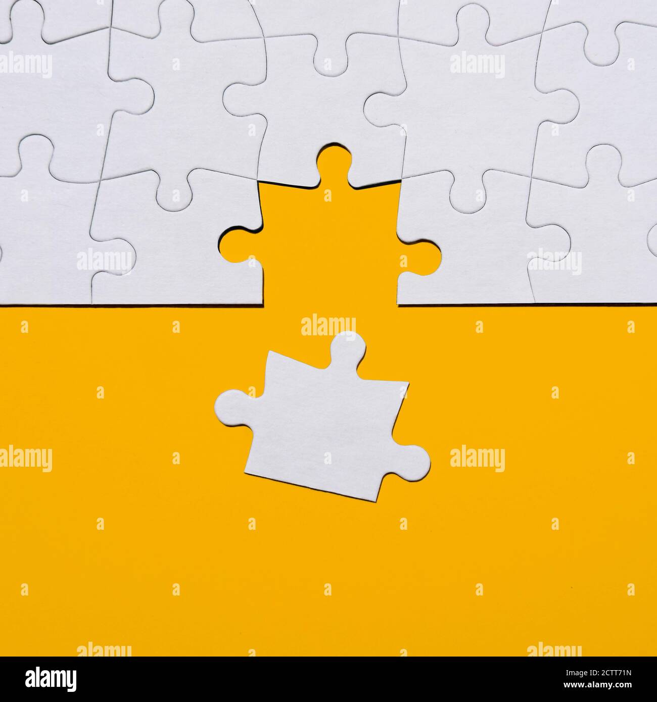 Last puzzle piece in jigsaw puzzle on yellow background Stock Photo - Alamy