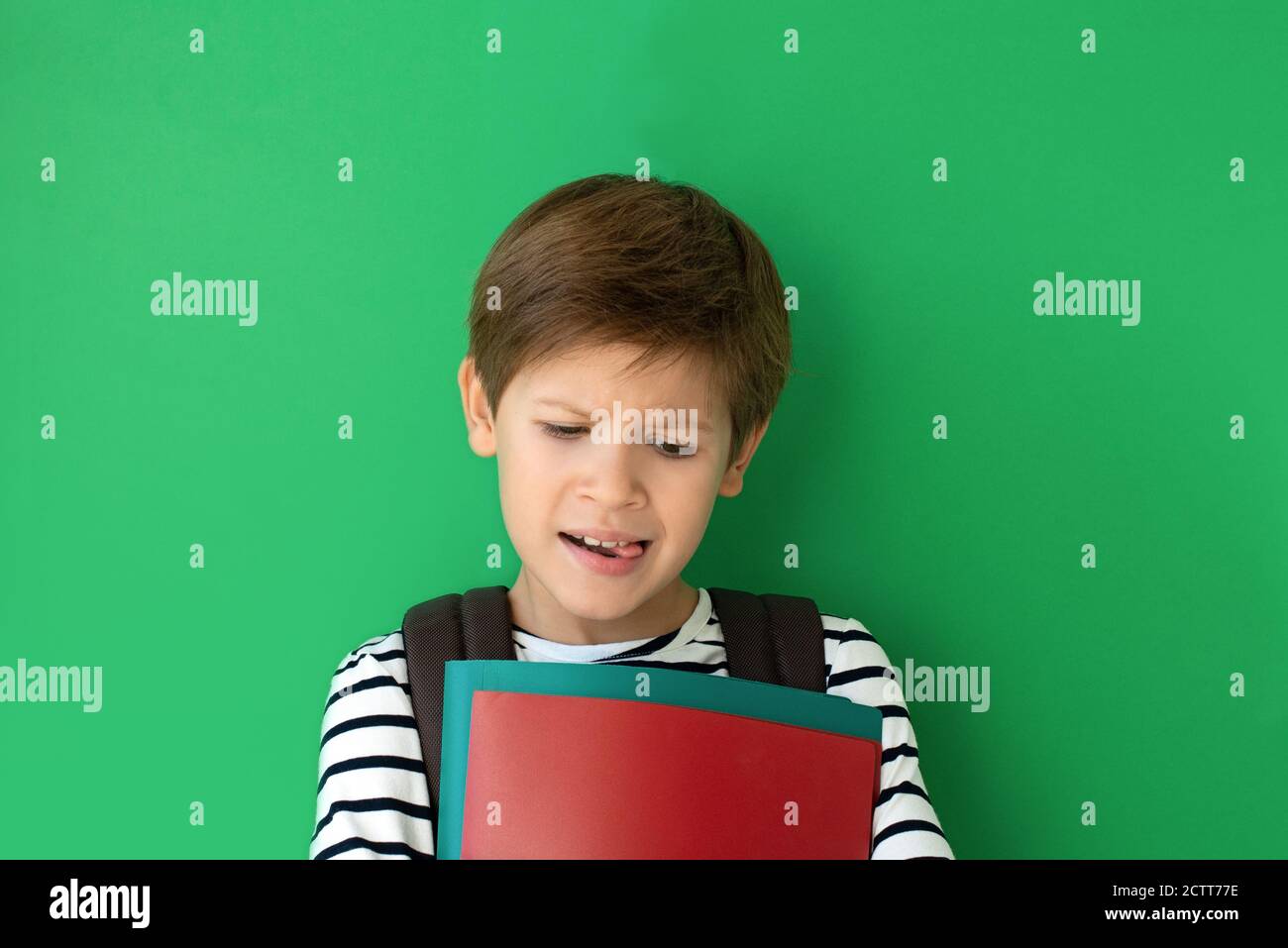 Schoolboy with a bored face with copy space. Pupil with a backpack and ...