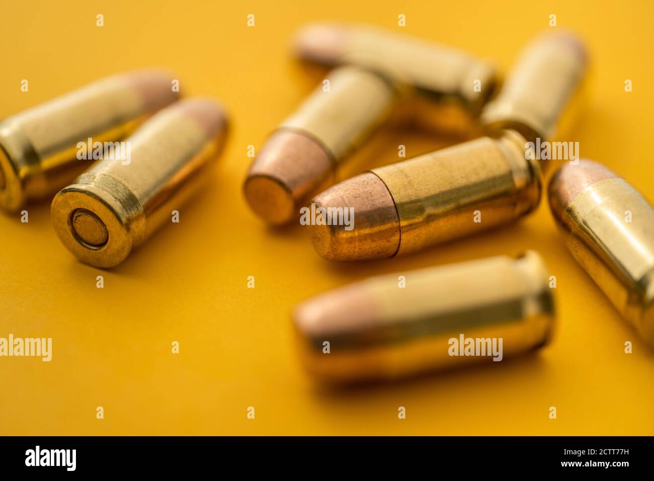 Brass bullets on yellow background Stock Photo - Alamy