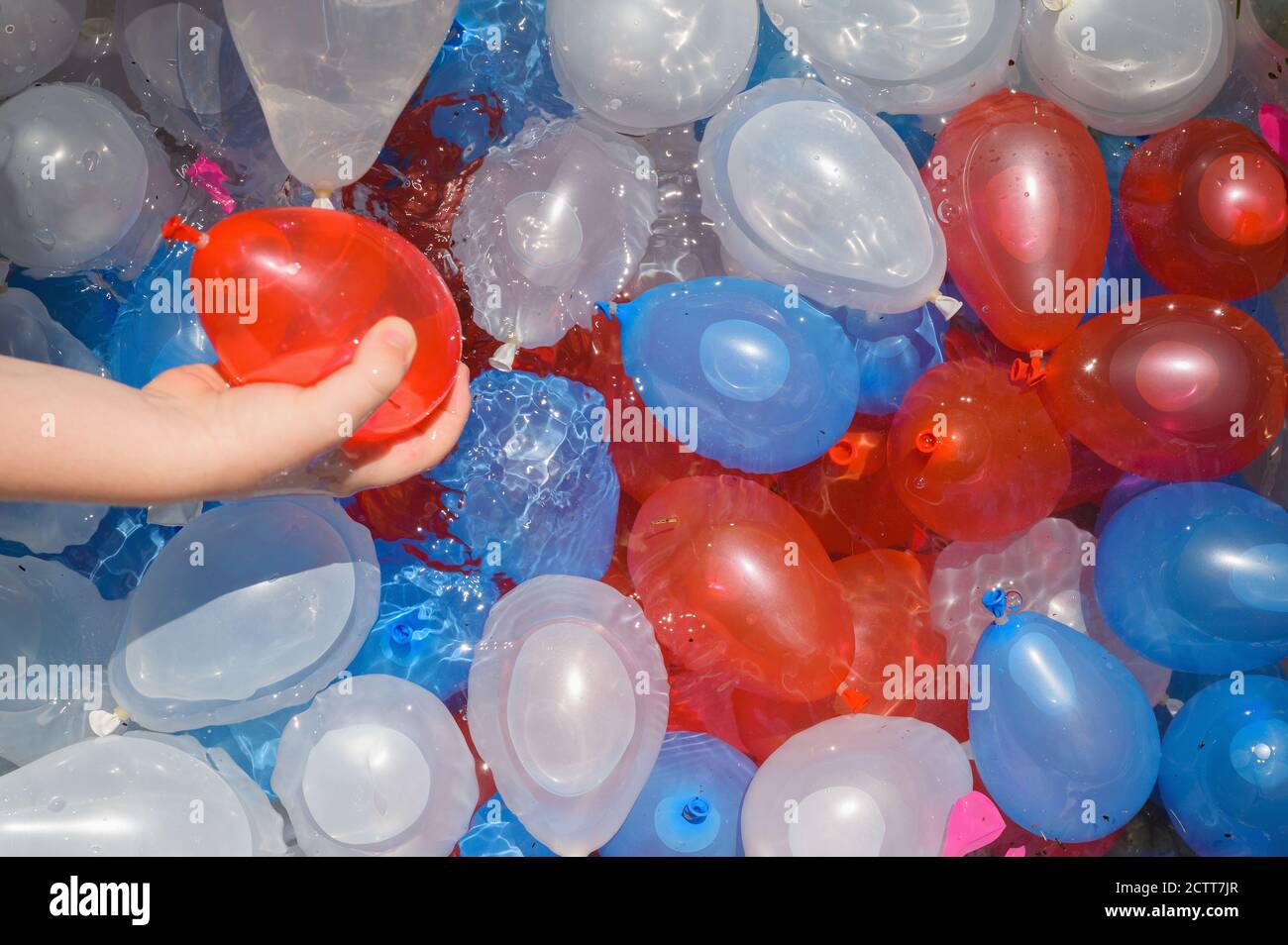 Close up of boy (4-5) playing with water balloons Stock Photo - Alamy