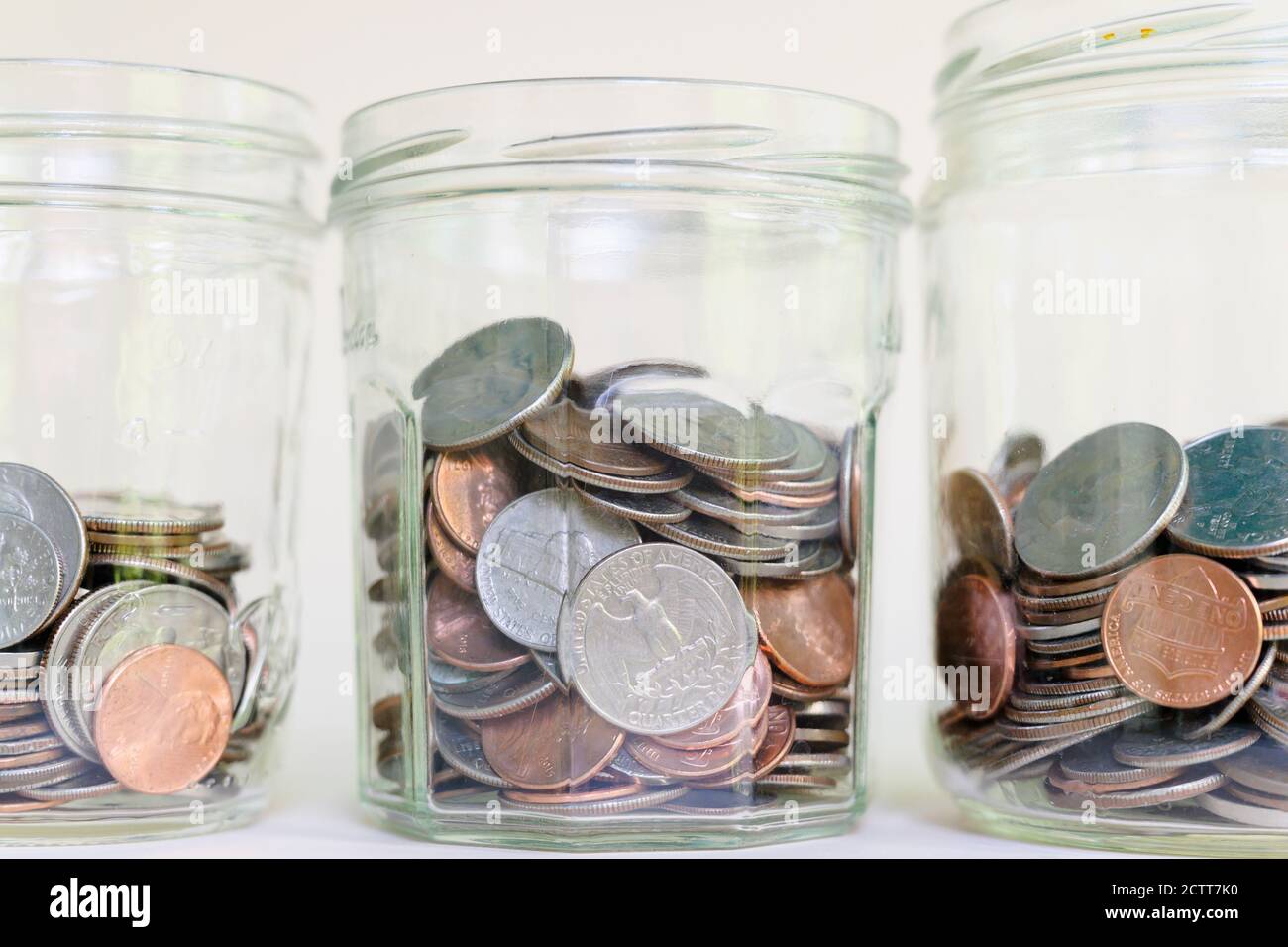 Jars with money on white background Stock Photo - Alamy