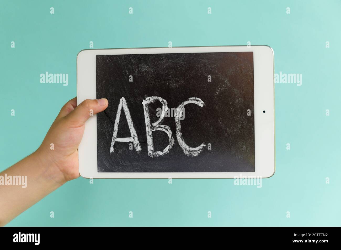 Hand of child (6-7) holding digital tablet showing alphabet Stock Photo ...