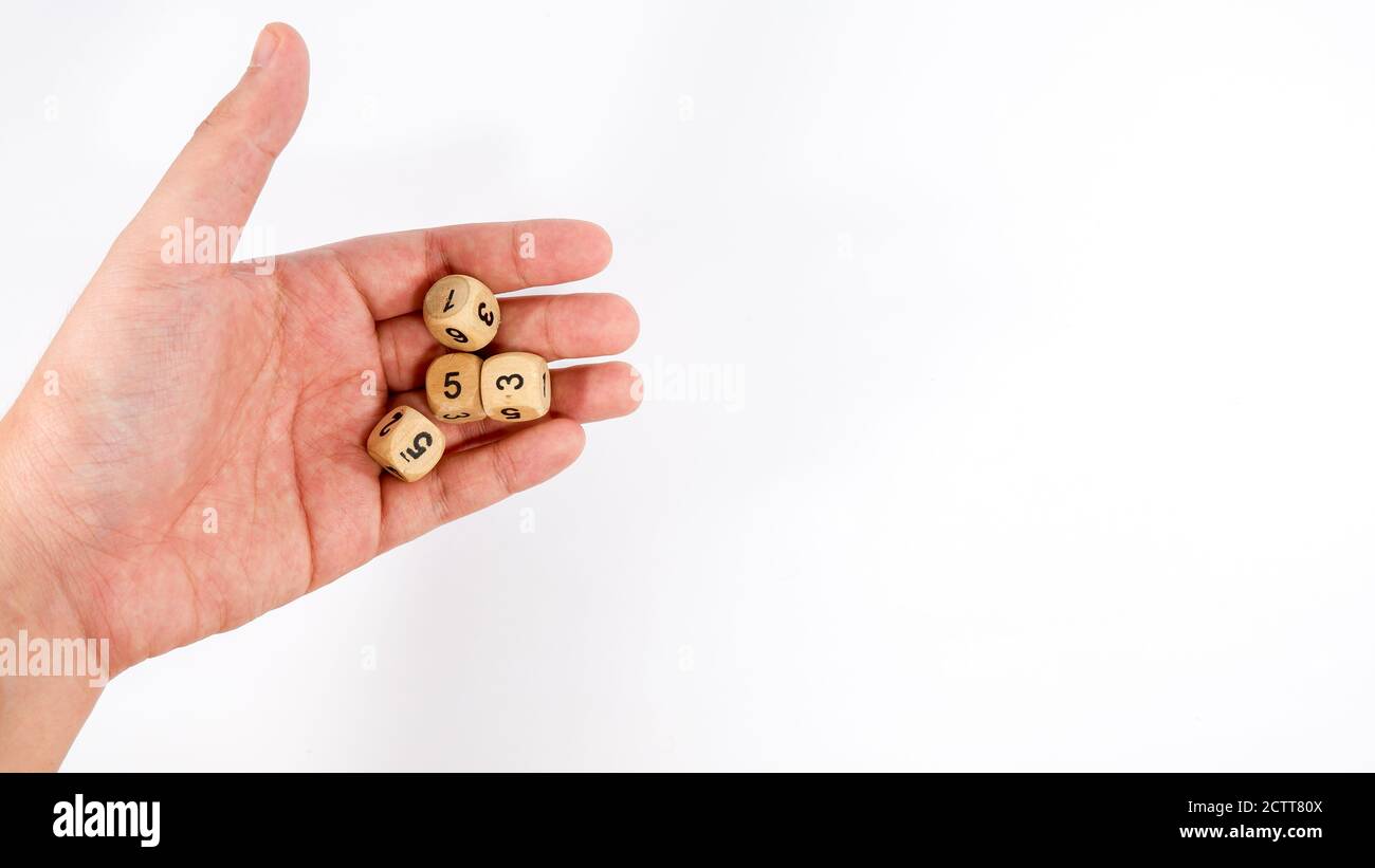 Rolling of wooden dice on hand Stock Photo - Alamy