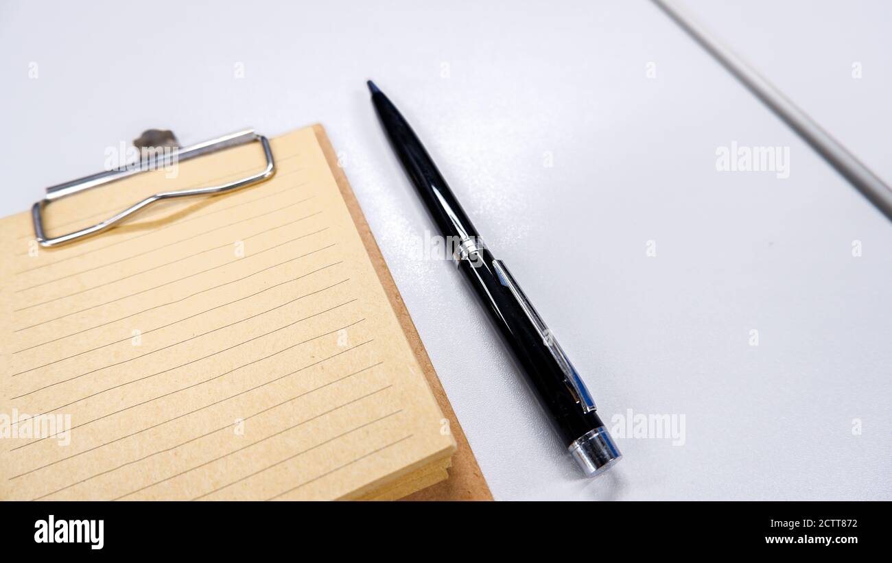 Notepad and pen on white office table Stock Photo - Alamy