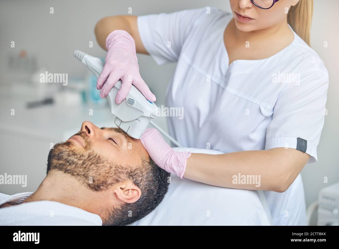 Bearded young man receiving laser facial treatment Stock Photo - Alamy