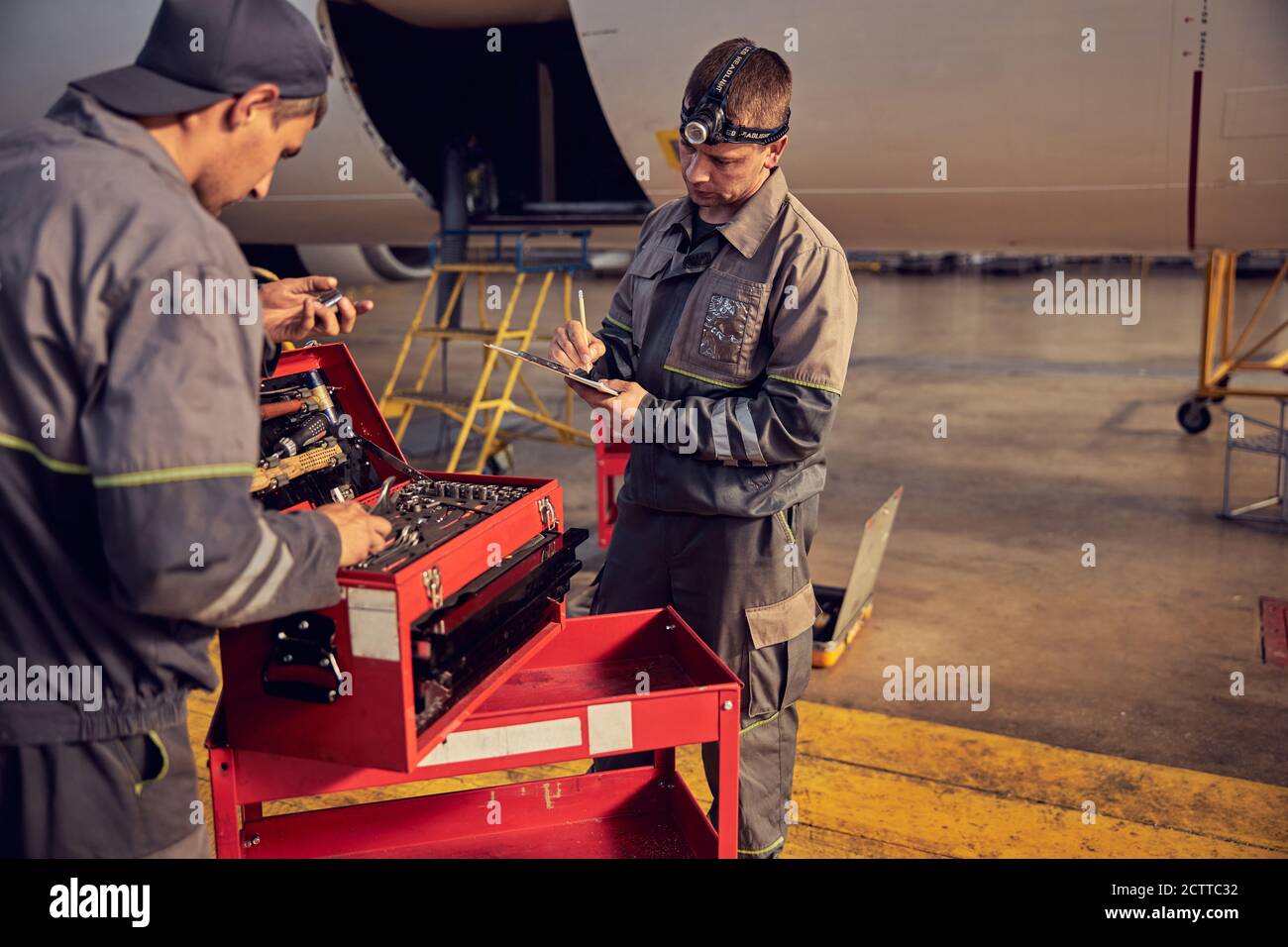 Two handsome seriously men in uniform using aviation equipments in the ...