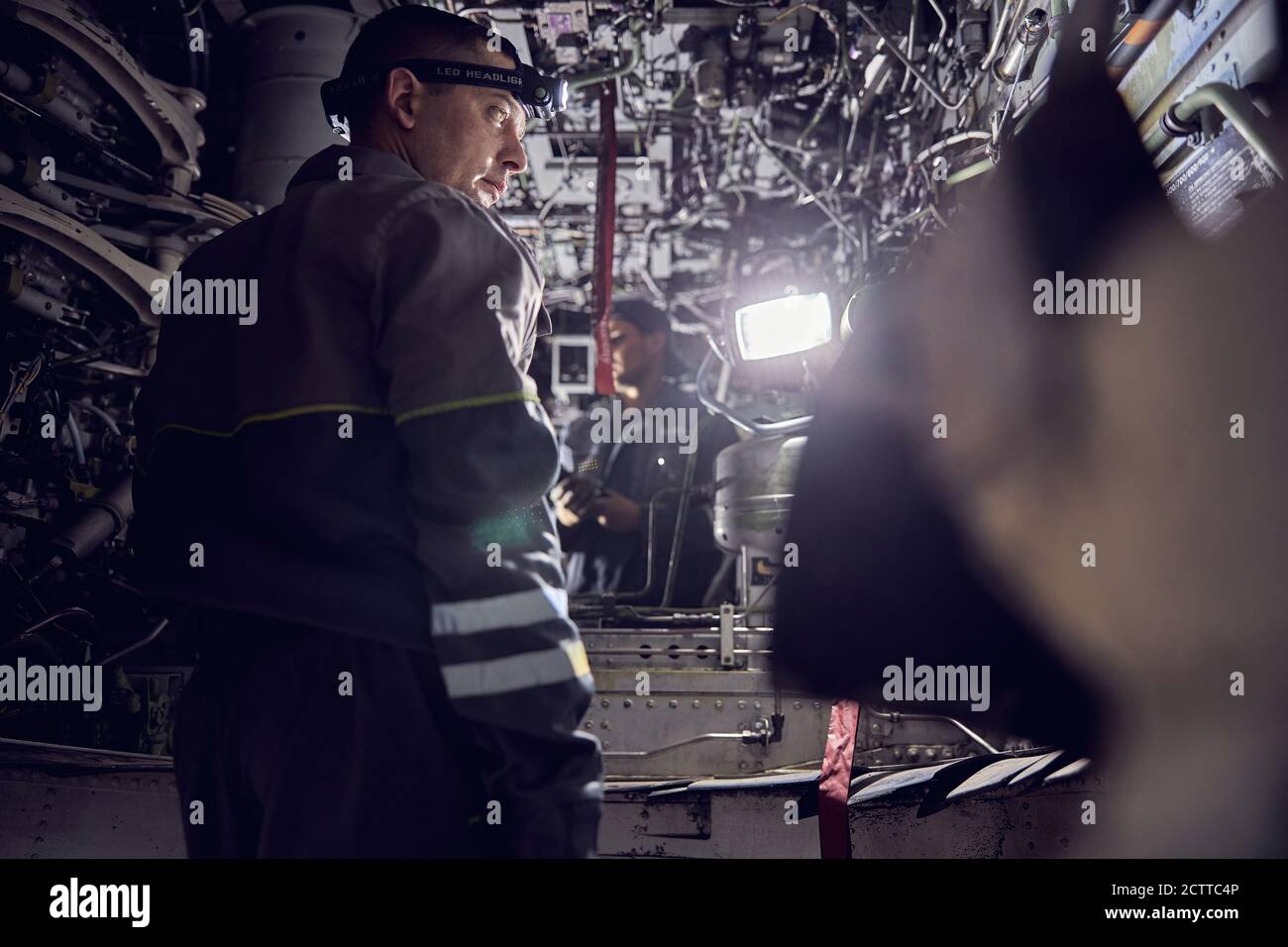 Adult mechanic man probing a jet engine of big airplane Stock Photo - Alamy