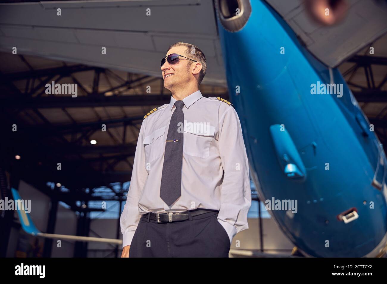 Smiling handsome man standing near the aviation hangar Stock Photo - Alamy