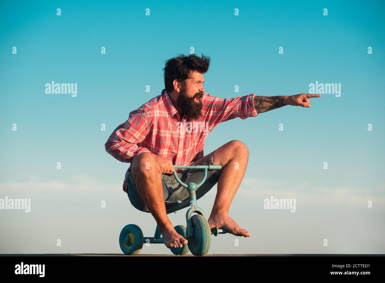 Funny man on small bicycle. Eccentric guy riding a bike Stock Photo - Alamy