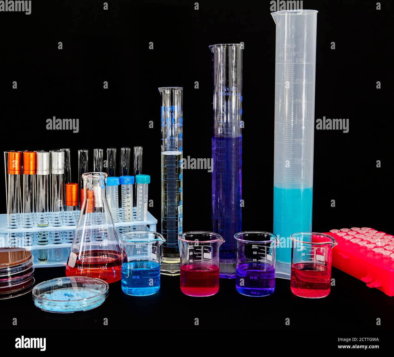 Chemical laboratory glassware with various colored liquids on table ...