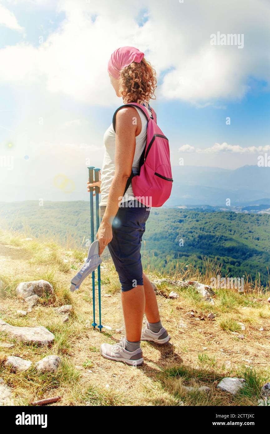 Woman takes rest during hiking in mountains in a sunny day Stock Photo ...