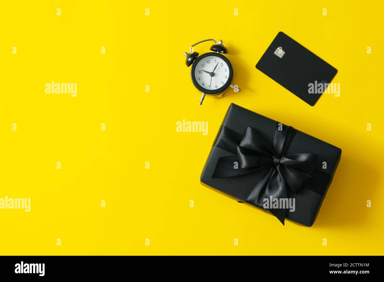 Gift box, alarm clock and card on yellow background Stock Photo - Alamy