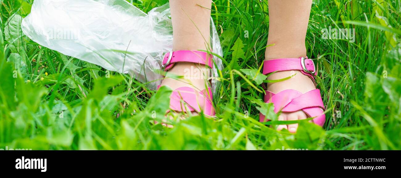 plastic bags trash with children's feet on green grass while cleaning ...