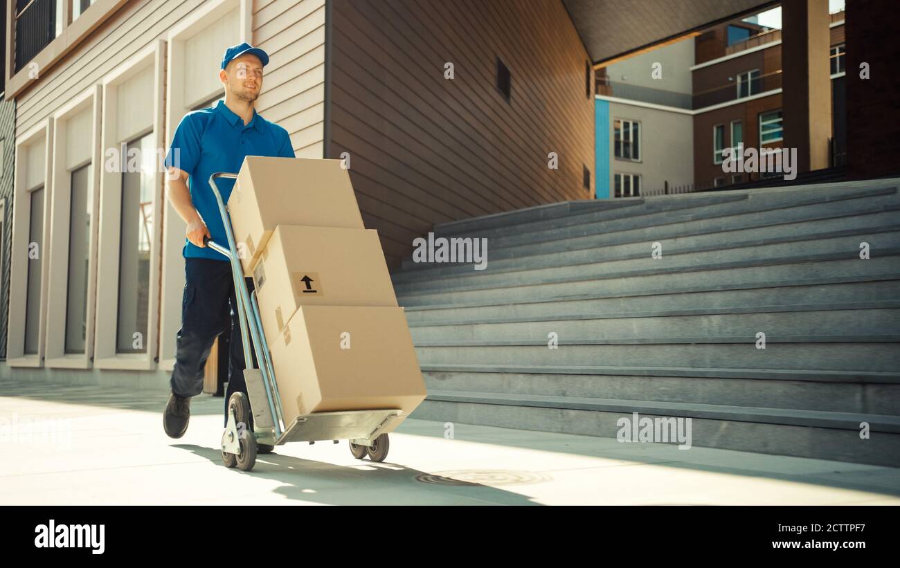 Happy Young Delivery Man Pushes Hand Truck Trolley Full of Cardboard ...