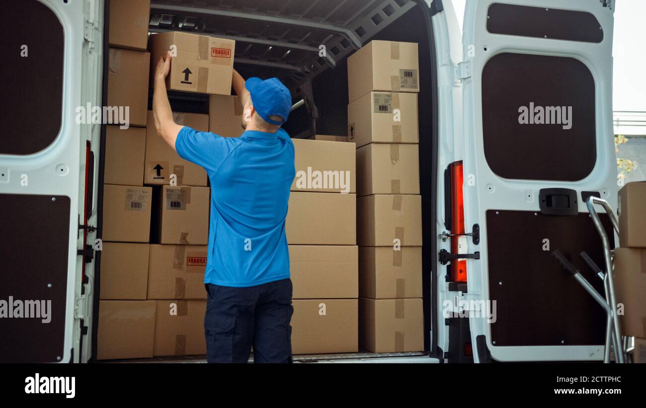 Courier Takes out Cardboard Box Package from Delivery Van Full of ...