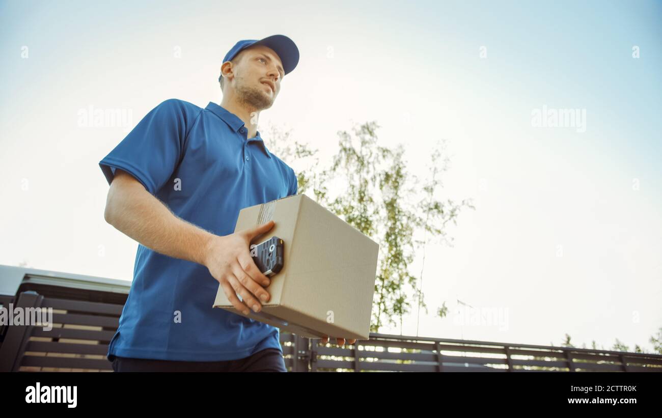 Low Angle Shot of Beautiful Young Delivery Man Delivering Cardboard Box ...