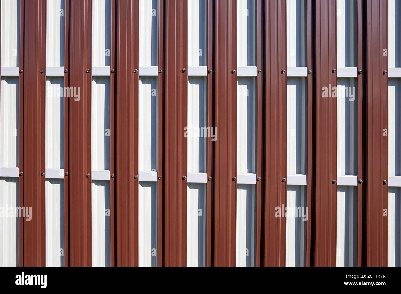 The reverse side of the fence made of corrugated board as a red-white ...