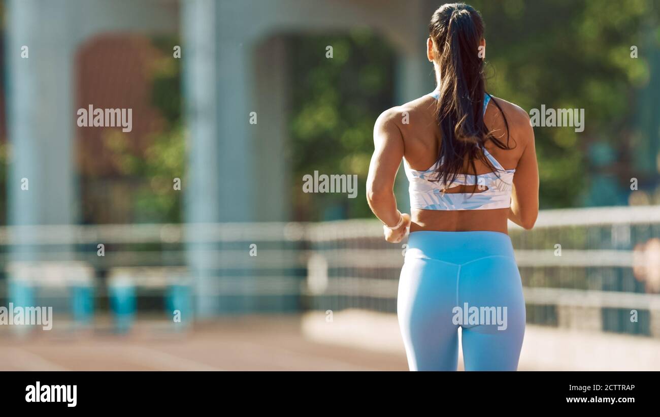 Beautiful Fitness Woman in Light Blue Athletic Top and Leggings Jogging ...