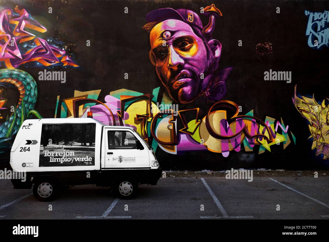 Colourful large graffiti street art on wall showing face and signatures ...